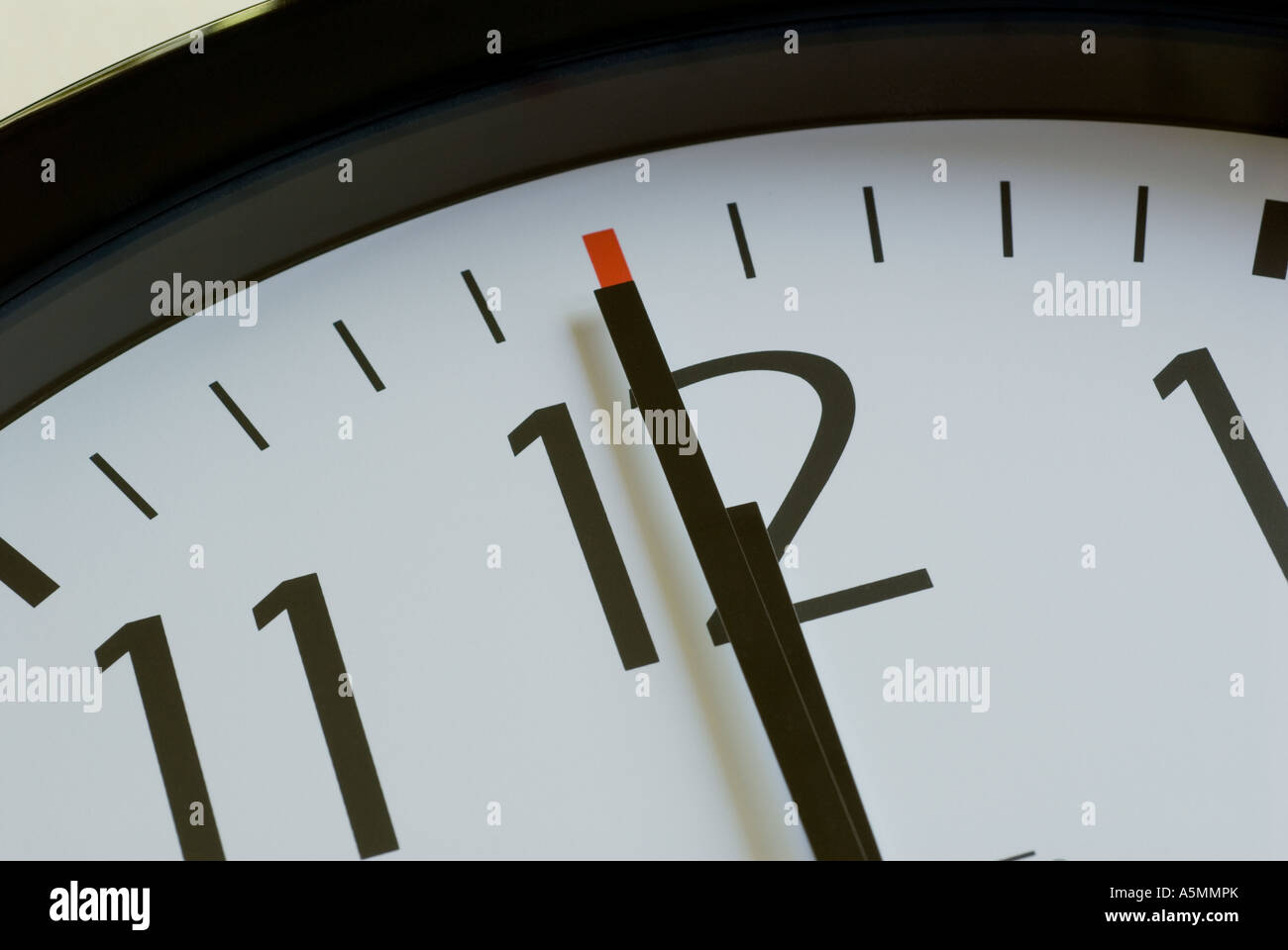 a black wall clock with a white face shows 12 o clock noon Stock Photo ...