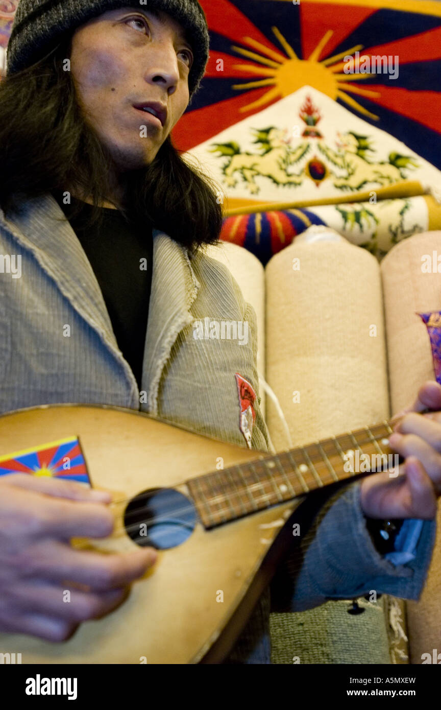 Young handsome Tibetan playing on traditional Tibet string instrument ...