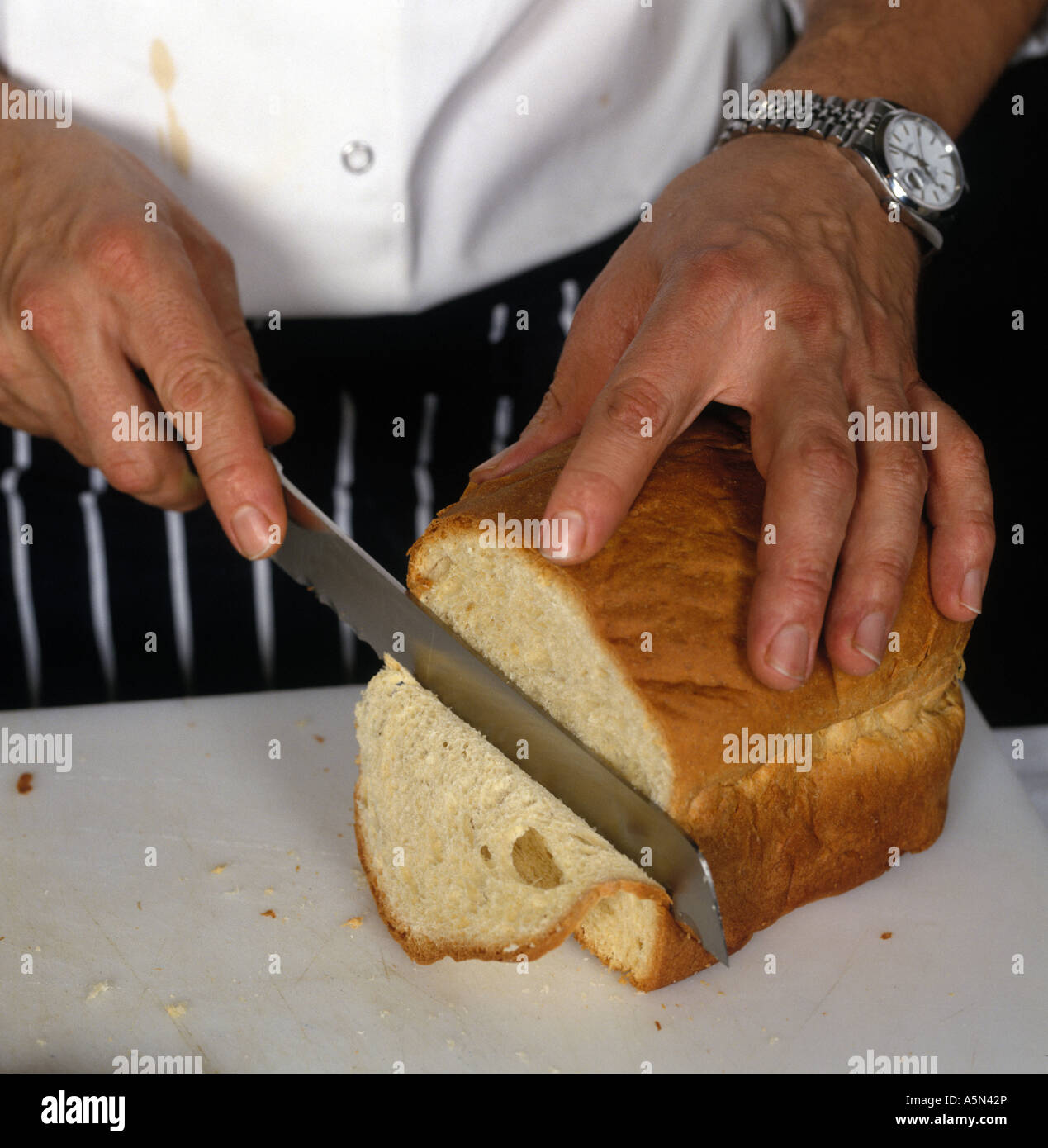 chef cutting a loaf of bread Stock Photo - Alamy