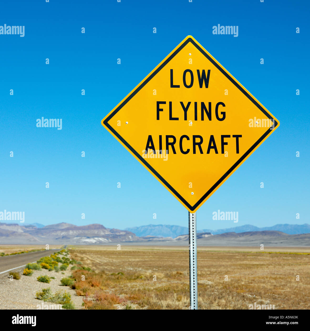 Low flying aircraft sign alongside desloate highway Stock Photo - Alamy