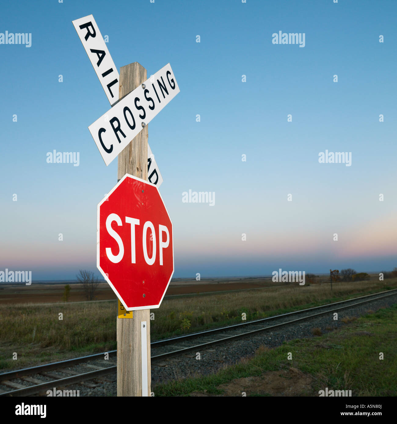 Railroad crossing and stop signs beside railroad tracks in rural ...