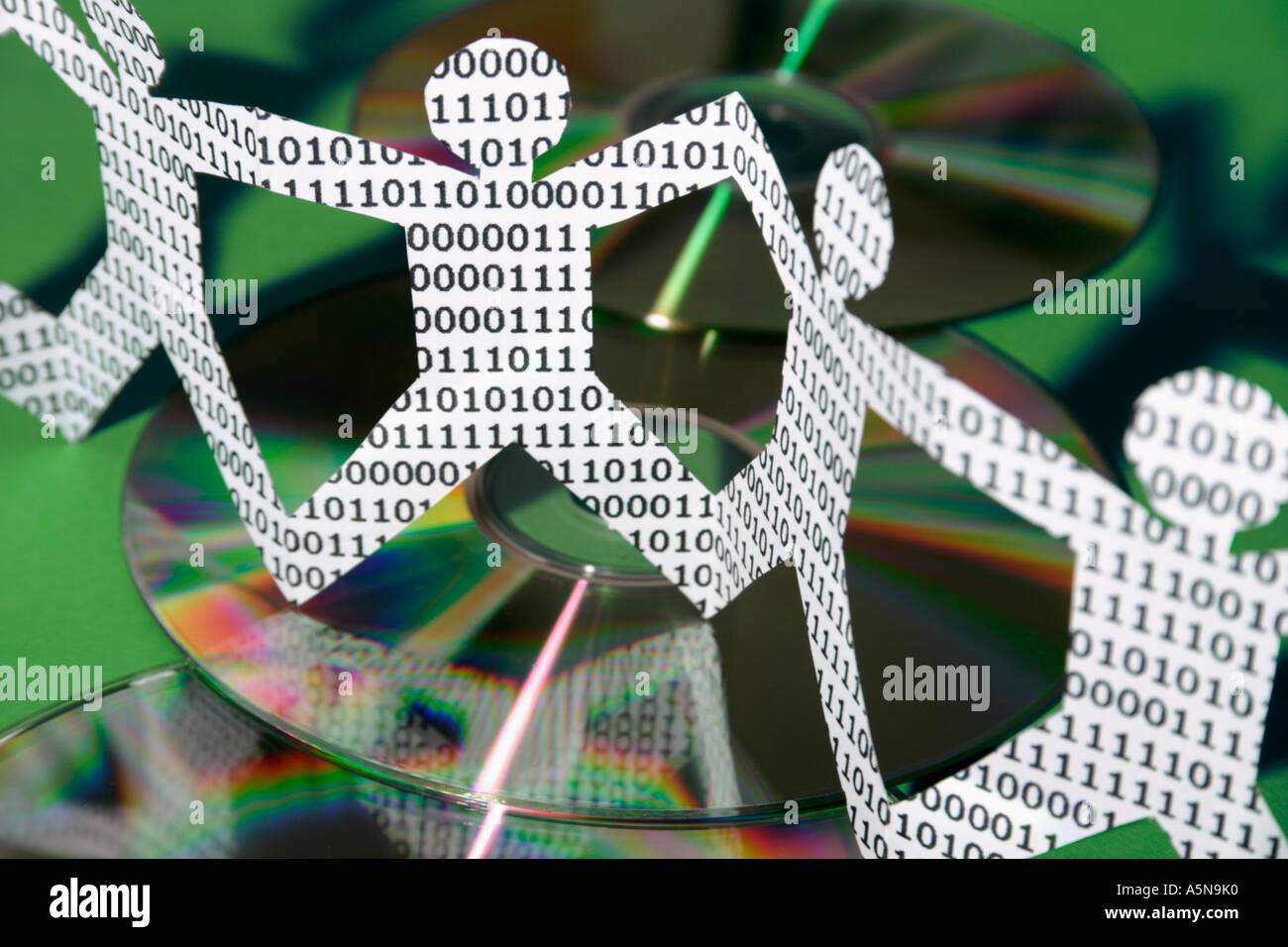 paper doll with binary numbers standing across compact discs. Concept ...