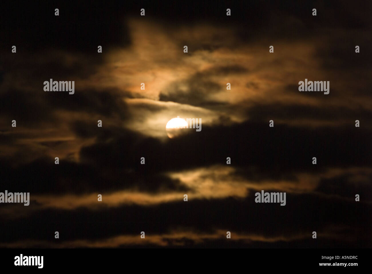Full moon shining through clouds at night Stock Photo - Alamy