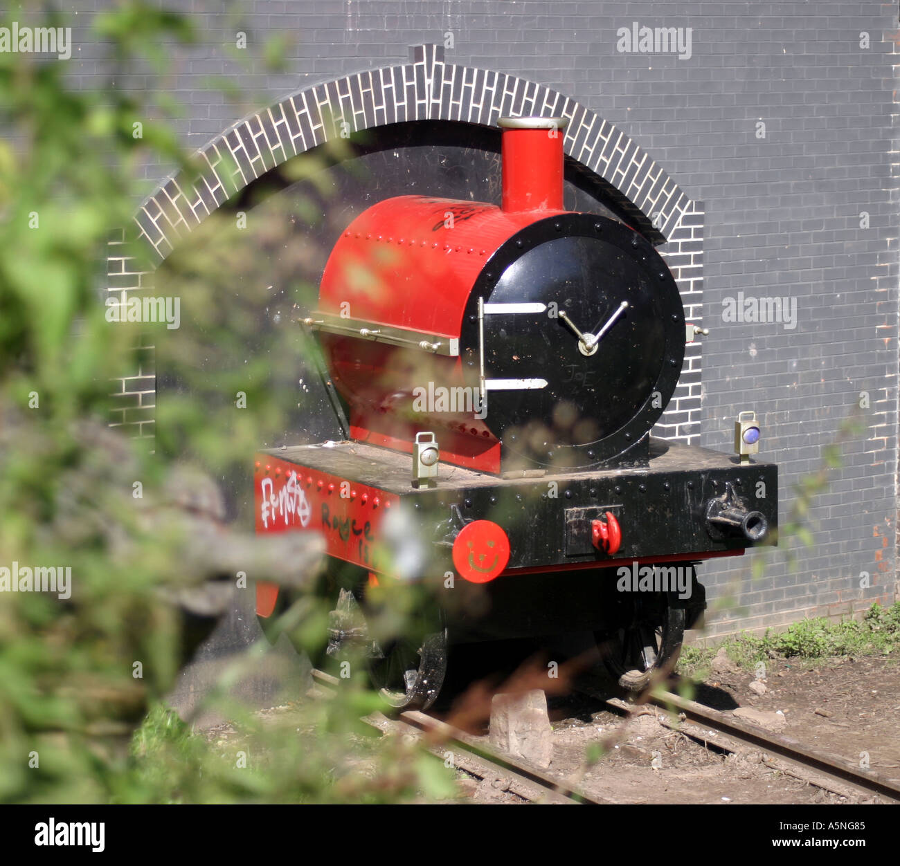 A train coming out of a tunnel The shell of an old steam train has been ...