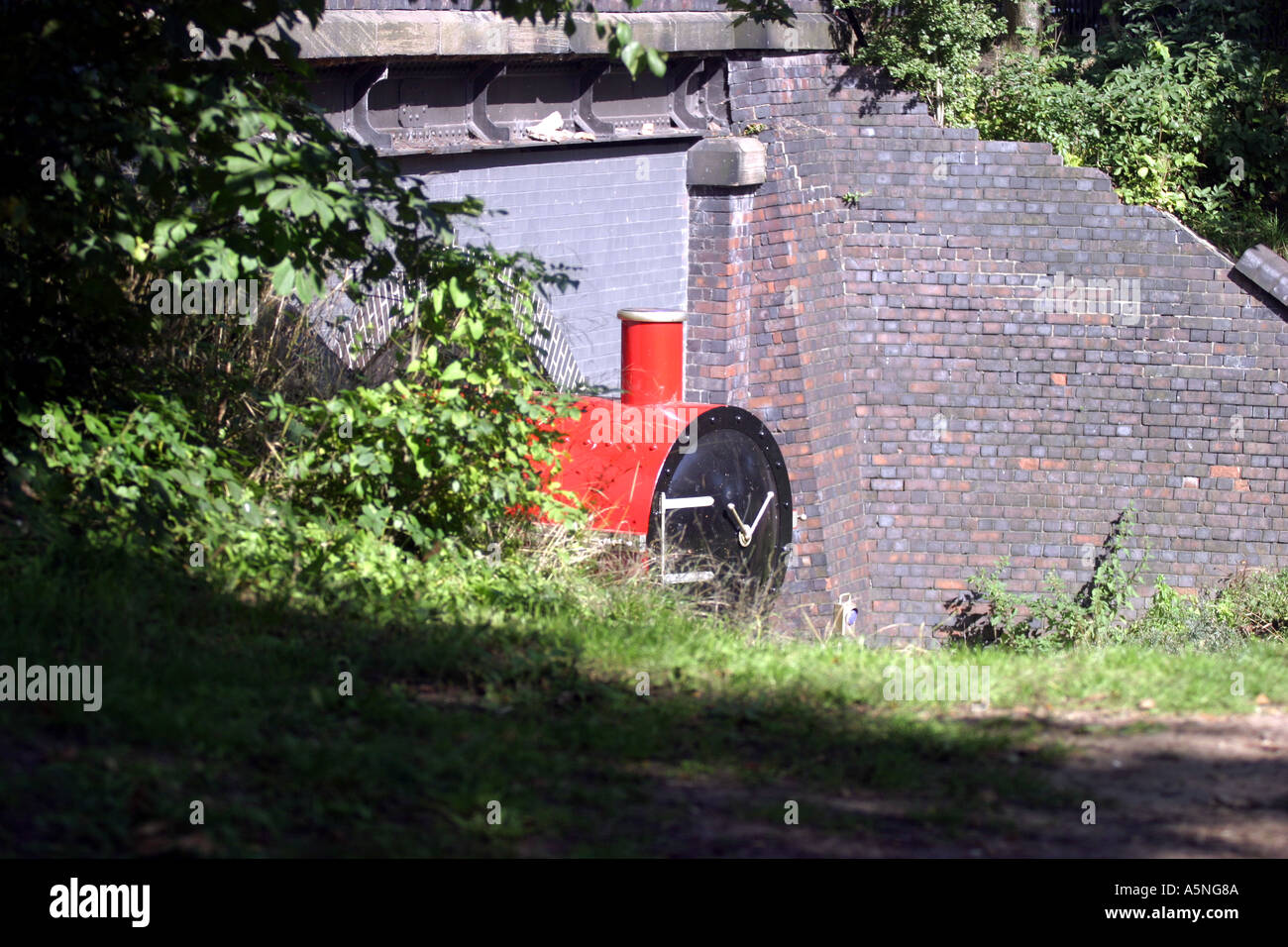 A train coming out of a tunnel The shell of an old steam train has been ...