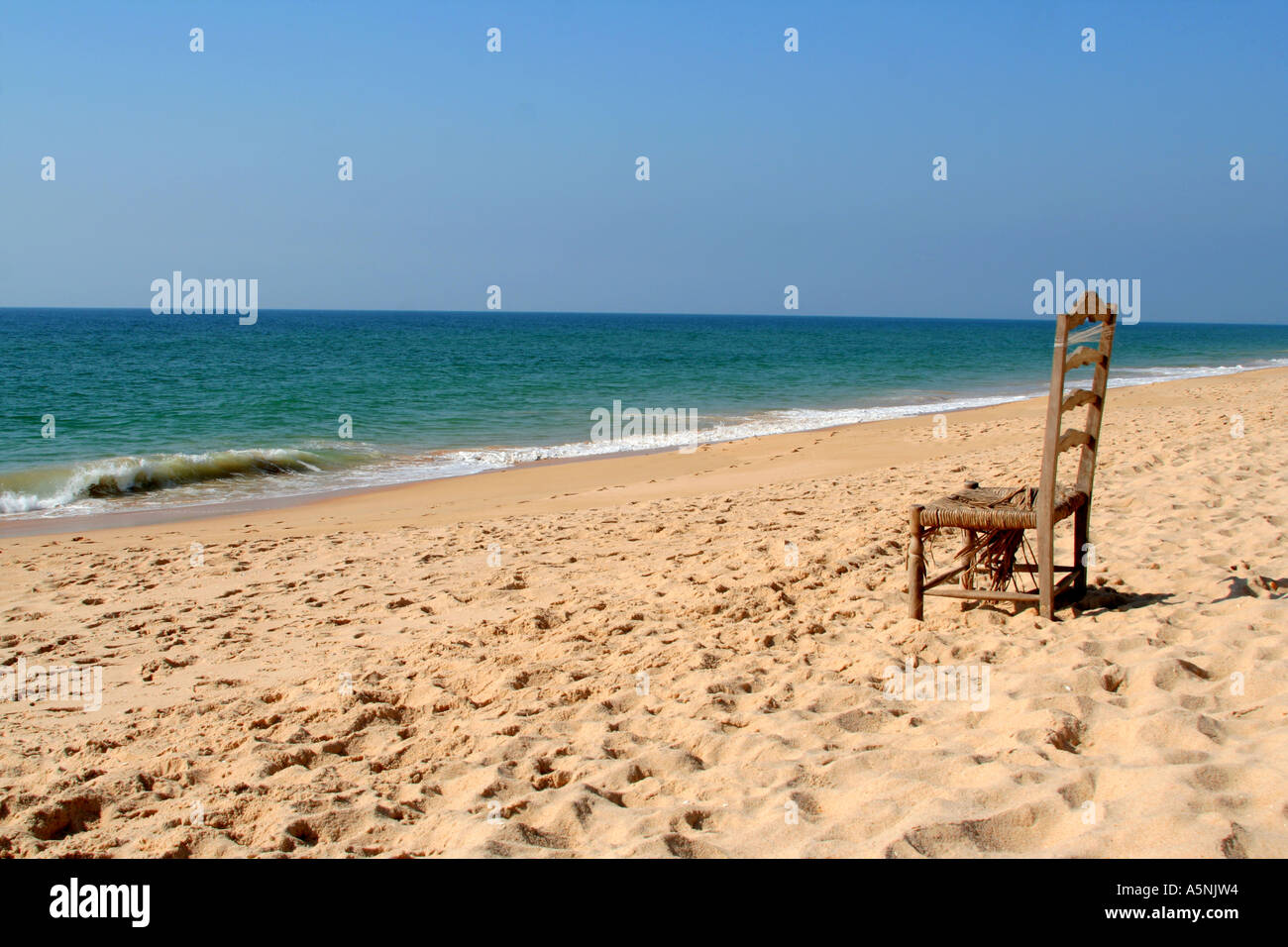 single ragged and tattered old chair on a deserted beach Faro Algarve ...