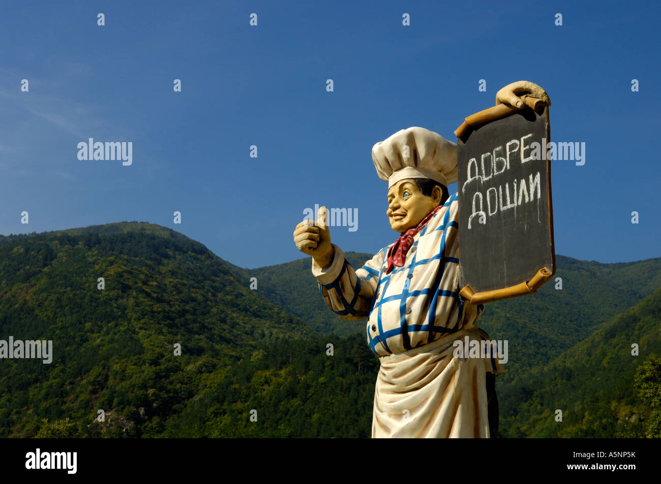 Chef mannequin holding tavern sign in Rodopi mountains Bulgaria East ...