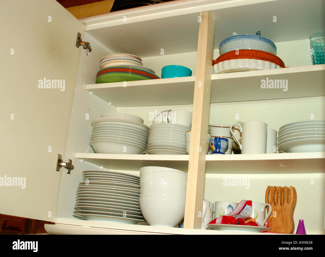 Domestic kitchen cupboard with doors open showing typical contents ...
