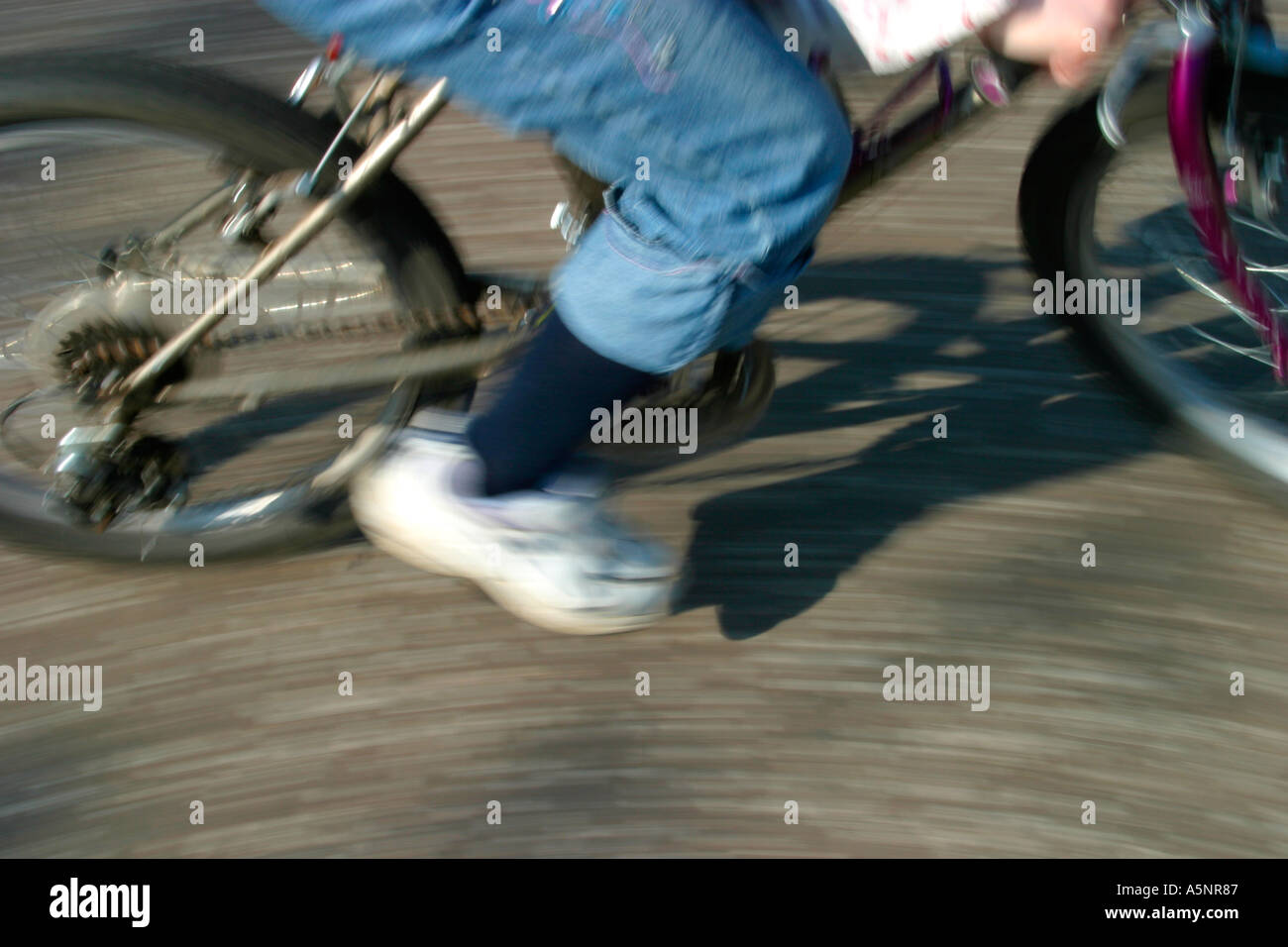 Panned image of child pedalling bicycle Stock Photo - Alamy