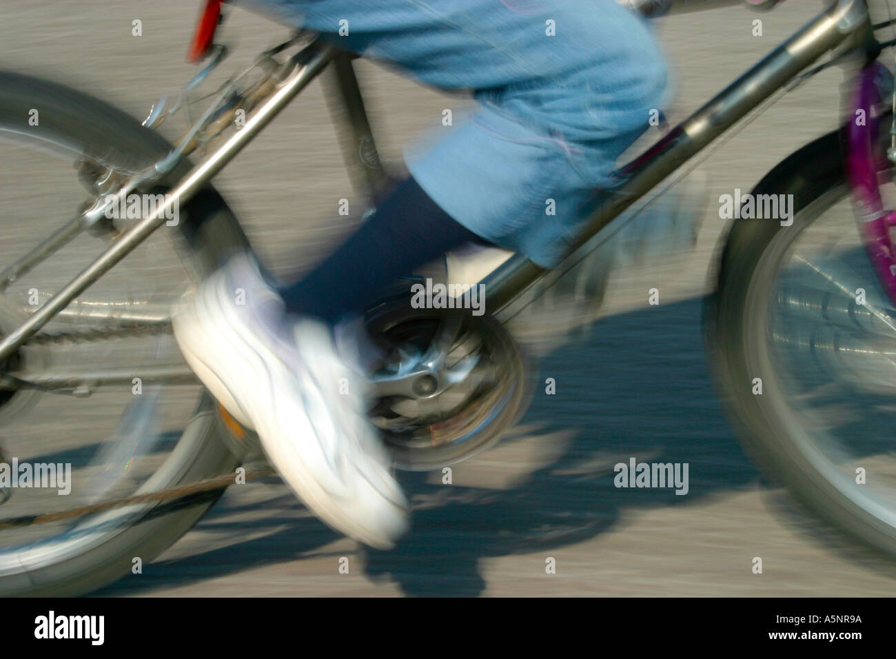 Panned image of child pedalling bicycle Stock Photo - Alamy