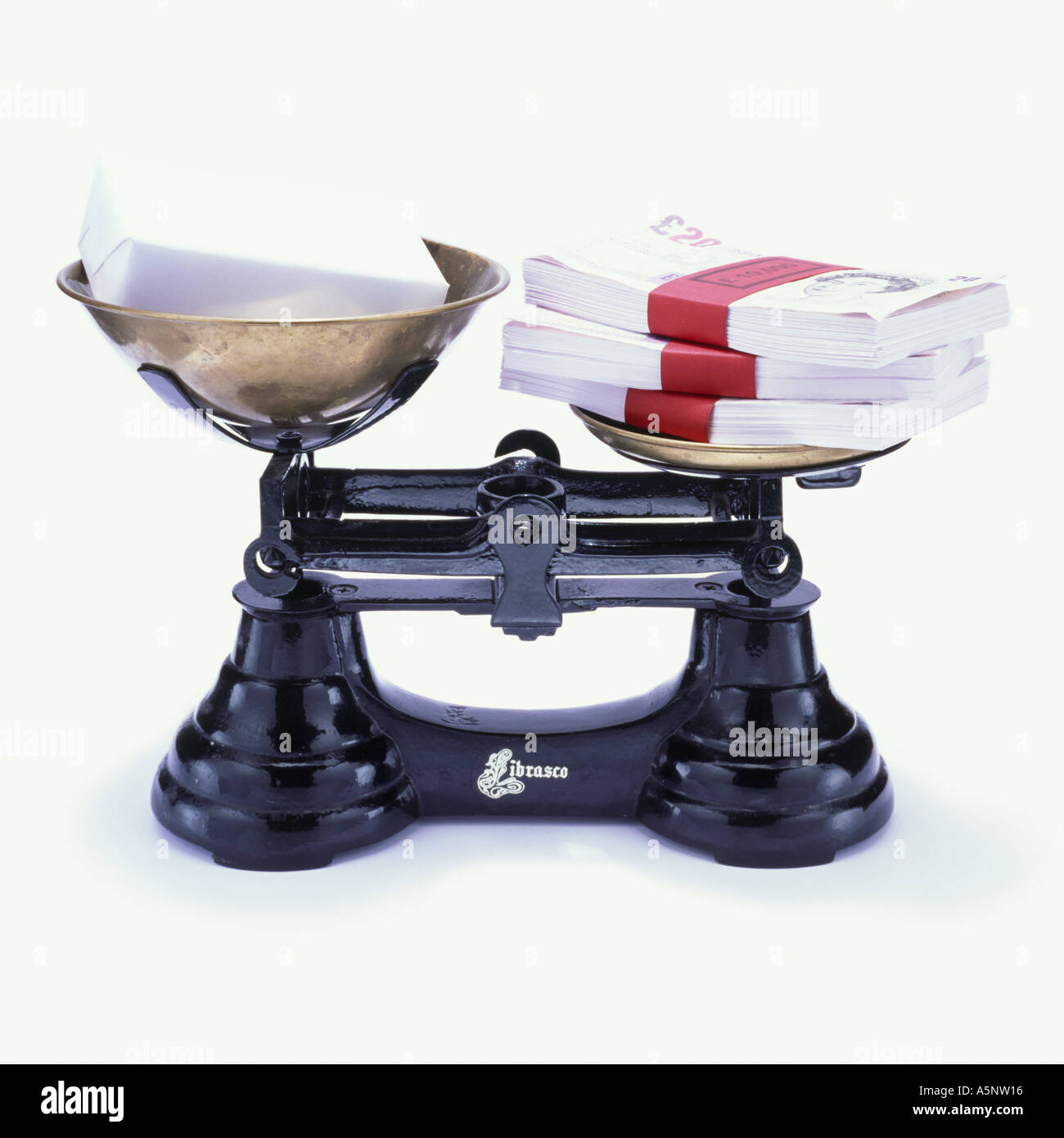 Measuring scales weighing money and paper Stock Photo - Alamy