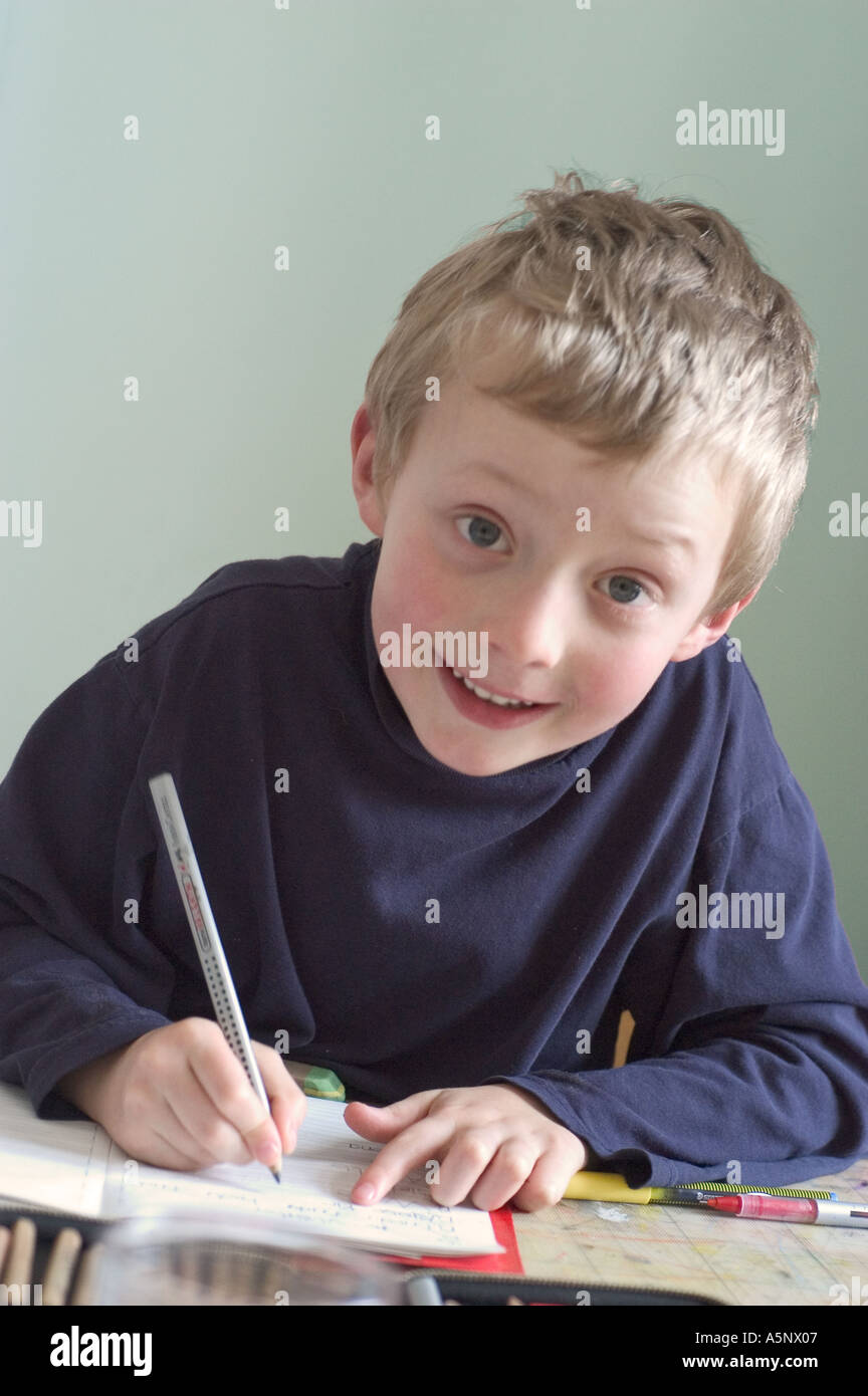 MR Six year old boy sitting at desk doing homework Stock Photo - Alamy