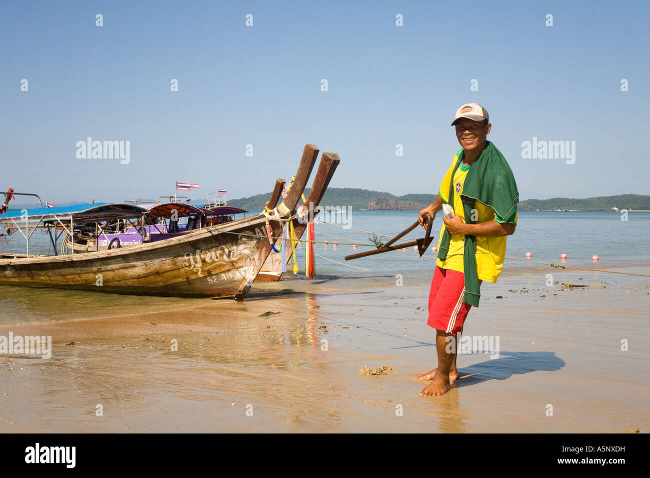 Boatman lifting anchor Krabi province beach resort Thailand Stock Photo ...