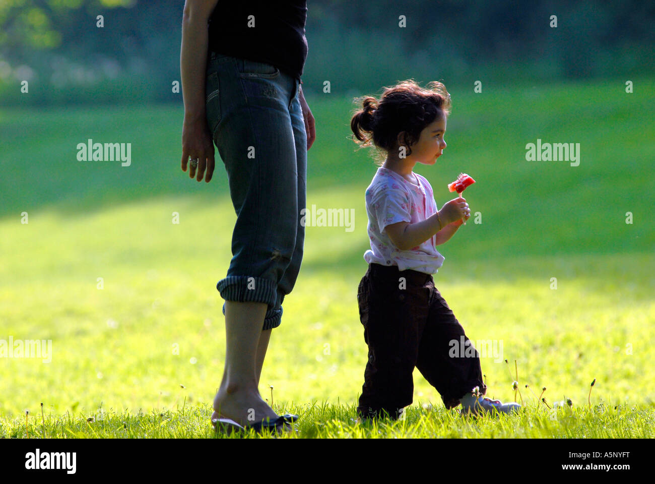 Young girl walking with mom Stock Photo - Alamy