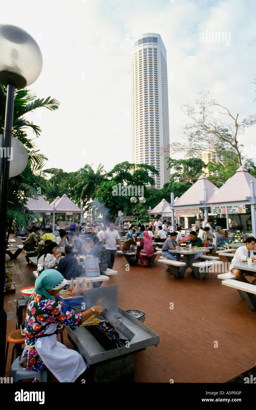Singapore. Outdoor eating in a hawker center, called Satay Club. Lady ...