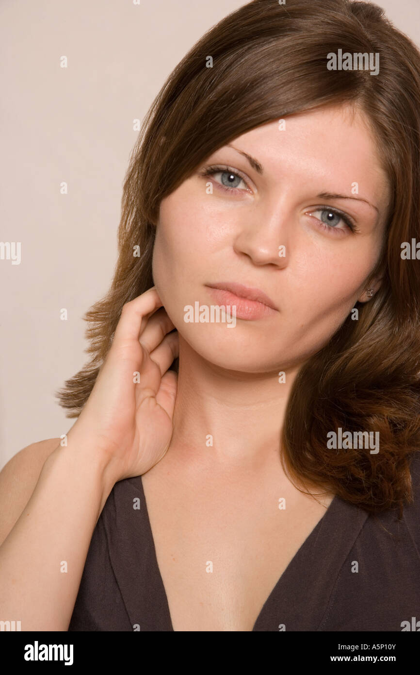 Young woman holding her neck Stock Photo - Alamy