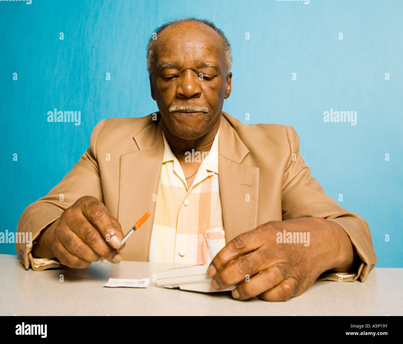 Mature adult prepares his insulin injection due to his diabetes Stock ...