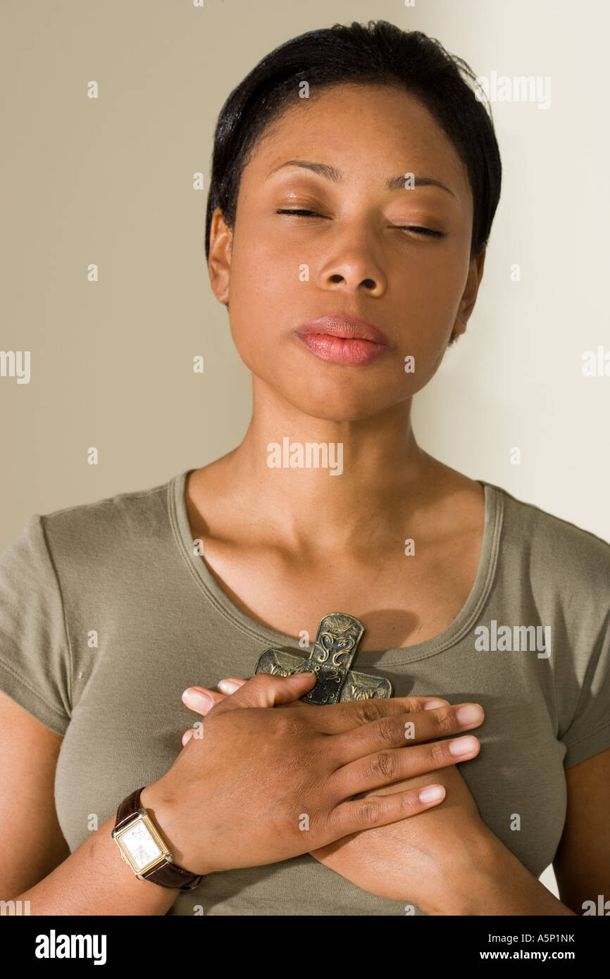 Woman praying with hands on her chest Stock Photo - Alamy