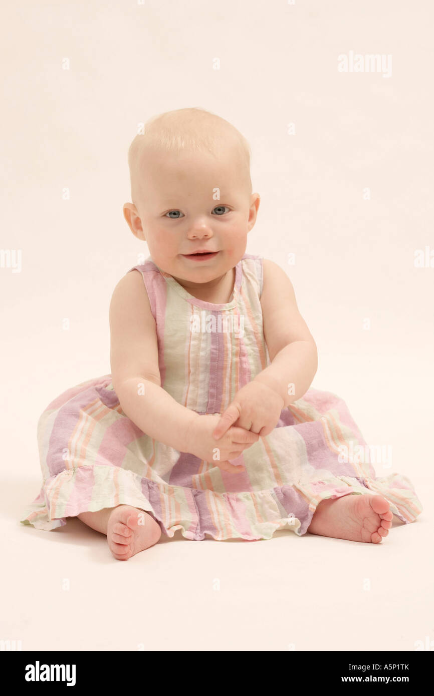 Eight month old baby girl sitting down Stock Photo - Alamy