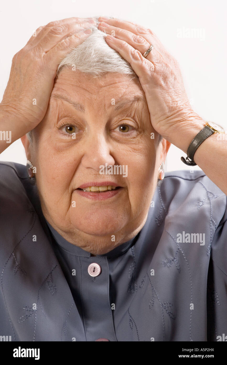 Mature woman holding her hands to her head Stock Photo - Alamy