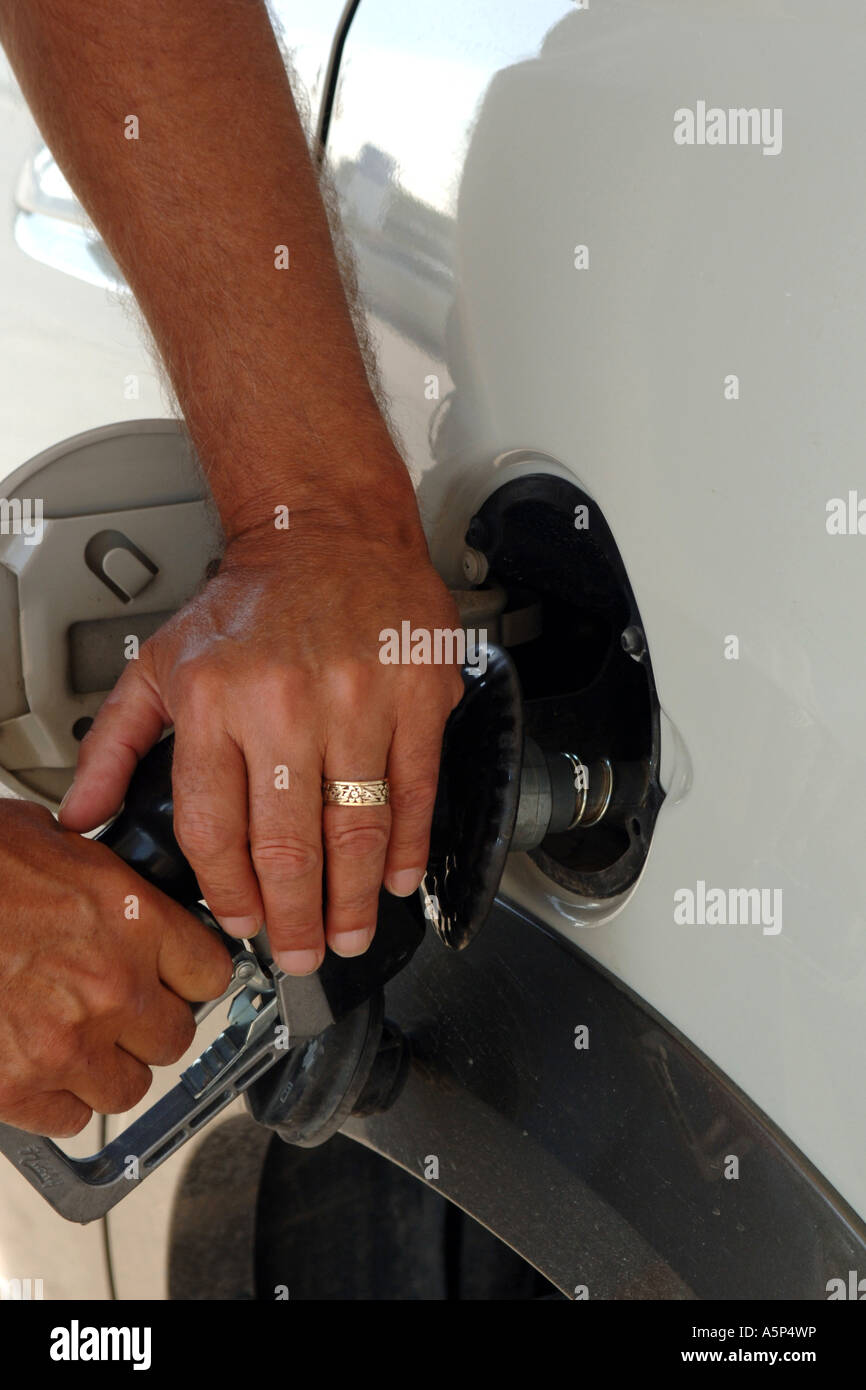 Adult male filling up his vehicle's fuel tank at a gasoline station ...