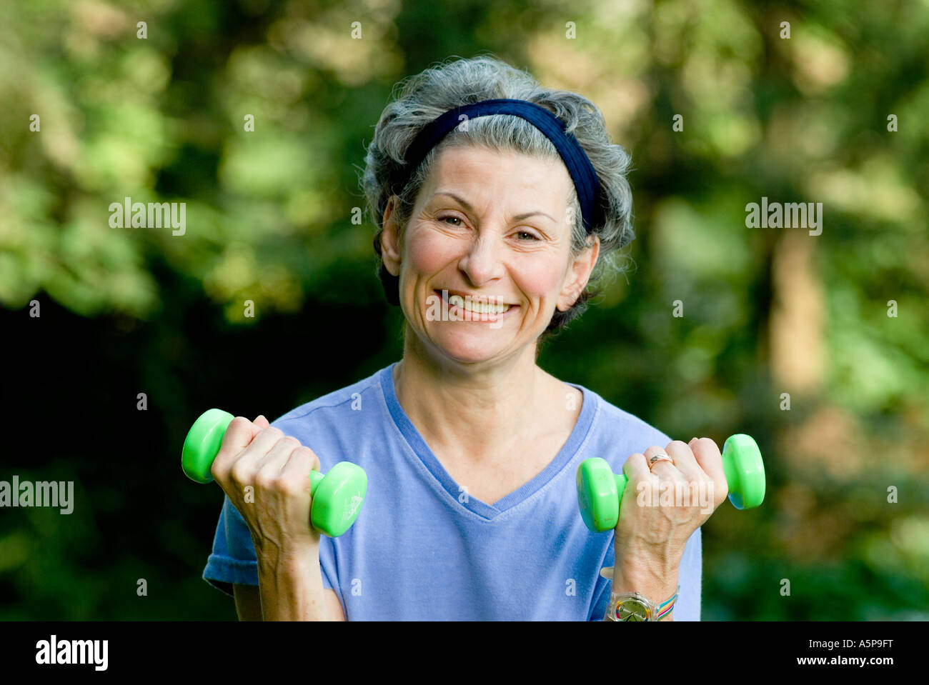 Older woman exercising outdoors with dumbell hand weights Stock Photo ...