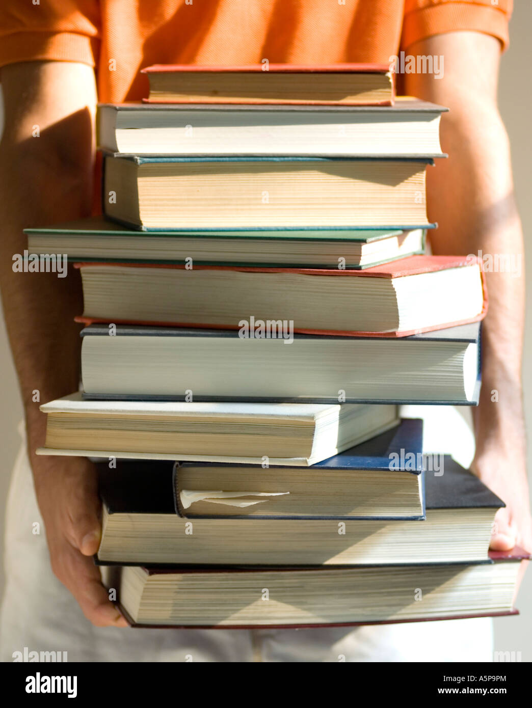 Hands holding textbooks Stock Photo - Alamy