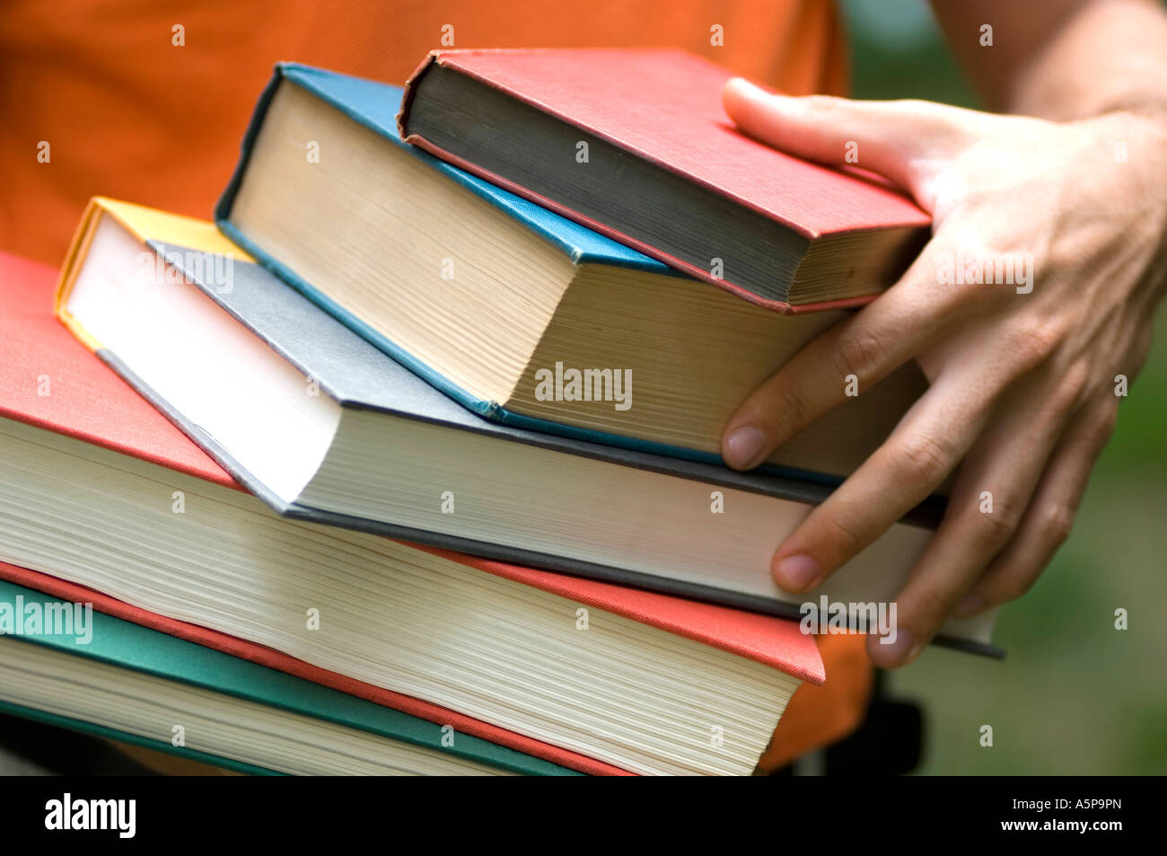Hands holding many school books and textbooks Stock Photo - Alamy