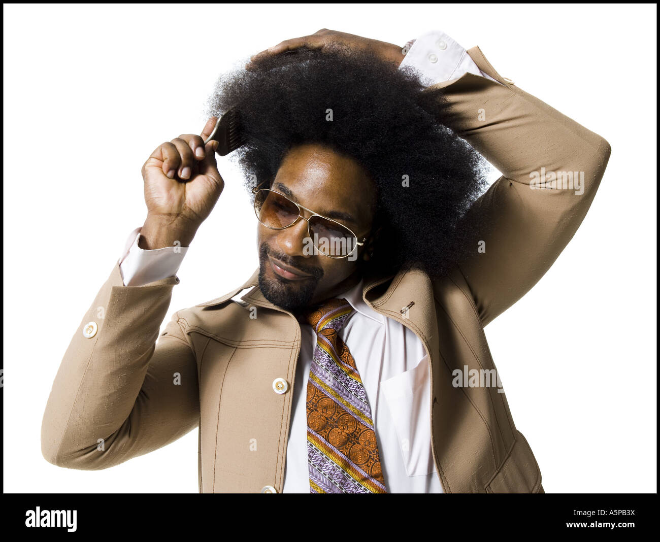 Man with an afro in beige suit combing with a hair pick Stock Photo - Alamy