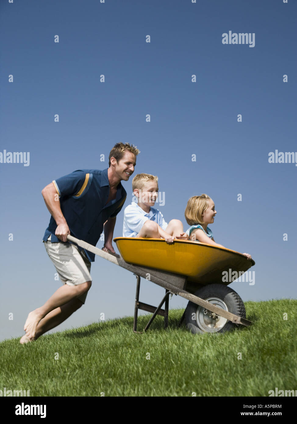 Father pushing son and daughter in a wheelbarrow Stock Photo - Alamy