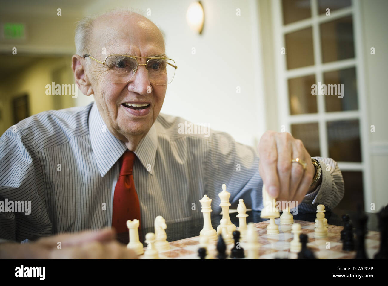 Elderly man playing chess Stock Photo - Alamy