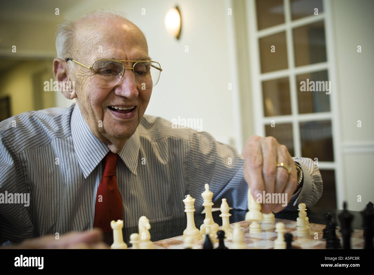 Elderly man playing chess Stock Photo - Alamy