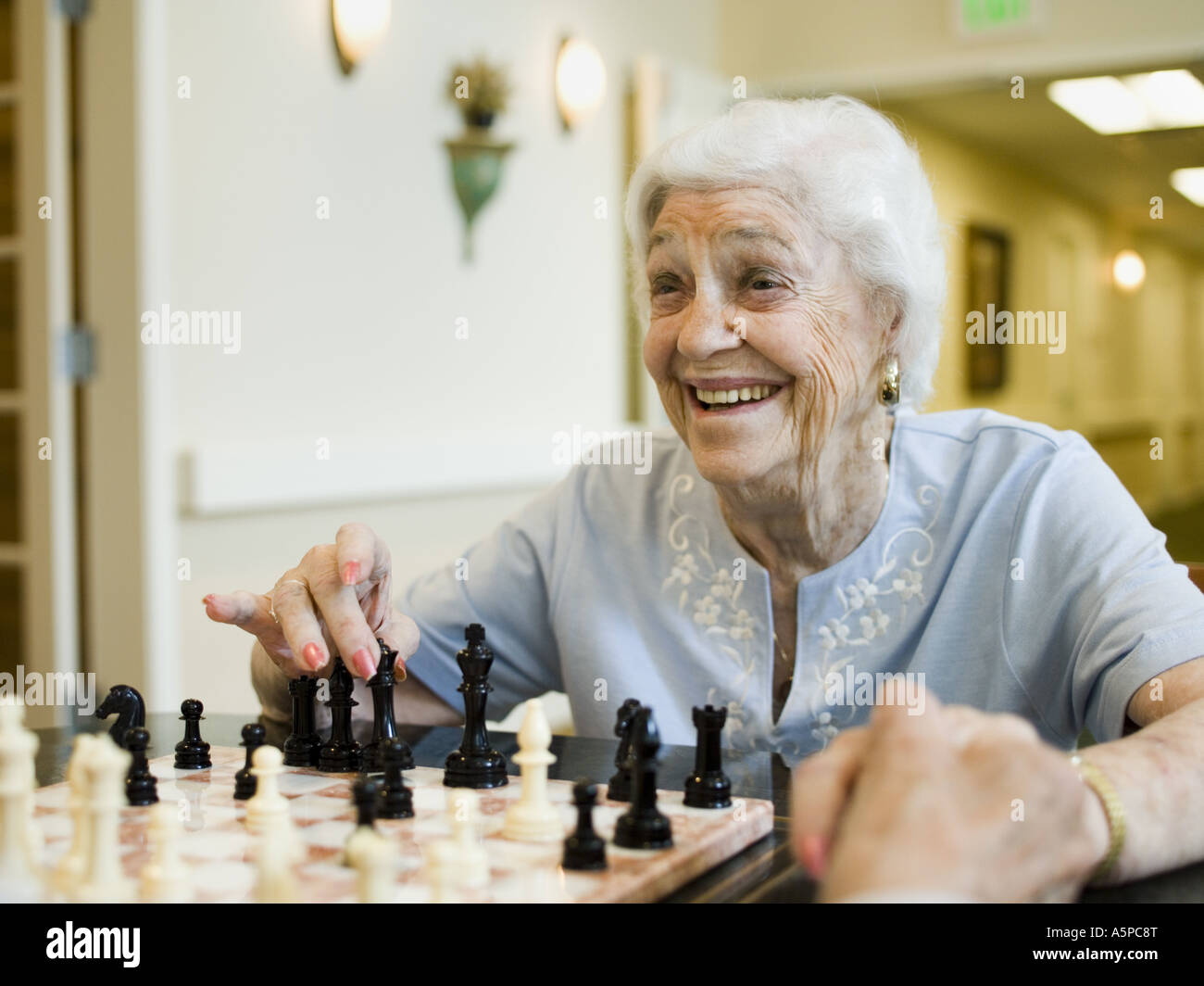 Elderly woman playing chess Stock Photo - Alamy