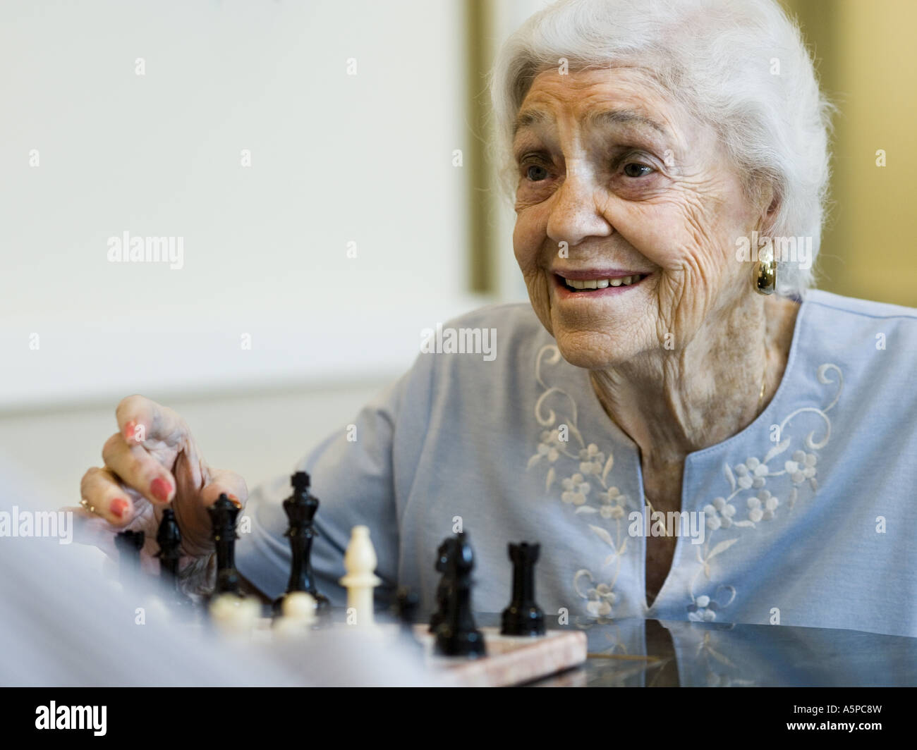 Elderly woman playing chess Stock Photo - Alamy