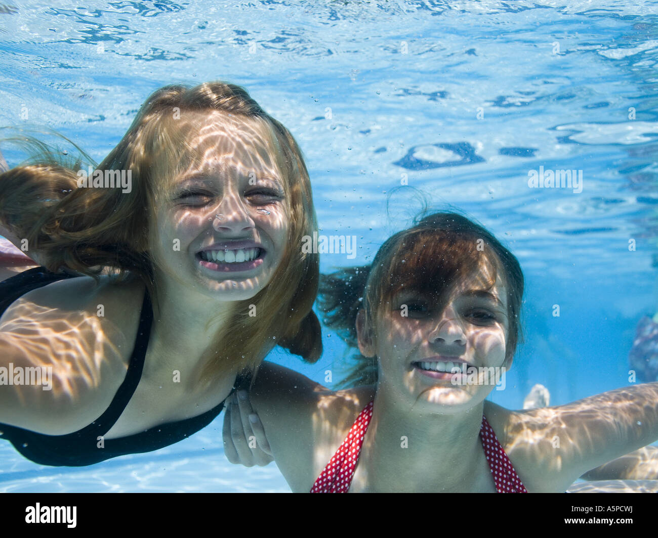 Girls swimming underwater in pool Stock Photo - Alamy