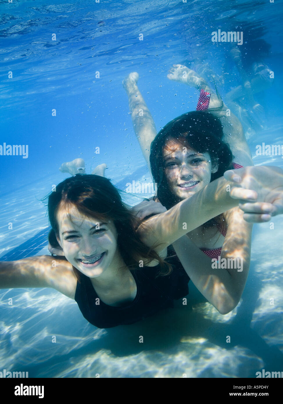 Girls swimming underwater in pool Stock Photo - Alamy