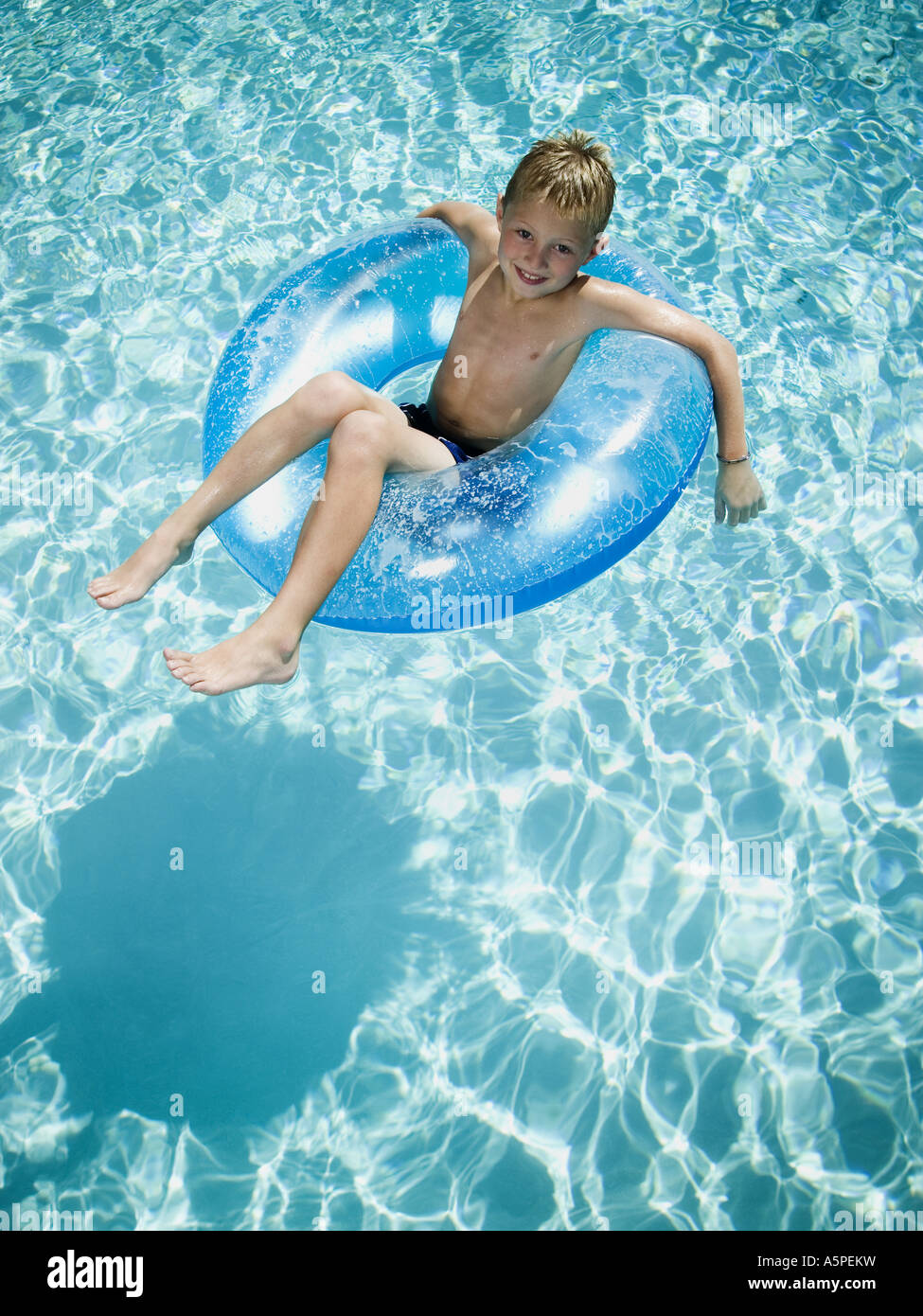 Young boy floating on life ring in swimming pool Stock Photo - Alamy