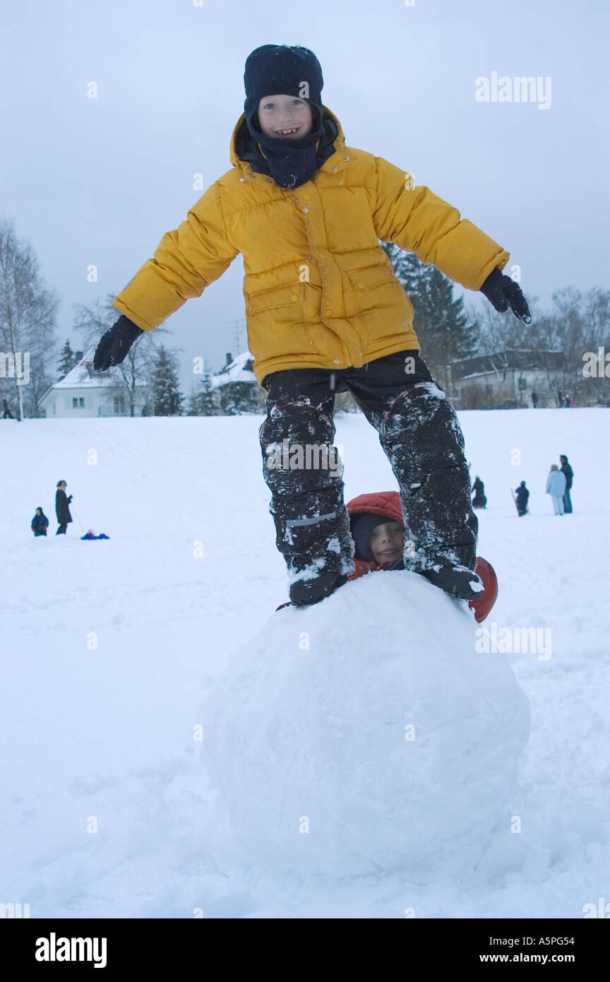 MR Little boy gazing throuh the legs of his brother standing on a big ...