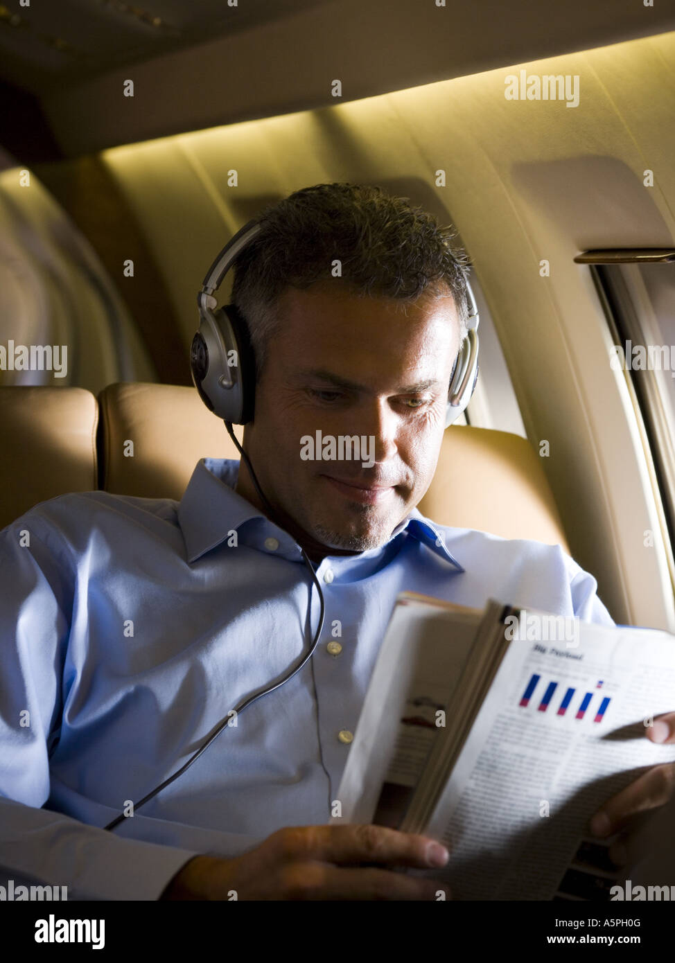A senior man reading a magazine in an airplane Stock Photo - Alamy