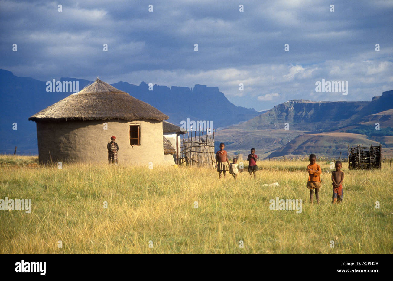 Zulu family outside their hut in the Drakensberg Mountains Natal South ...
