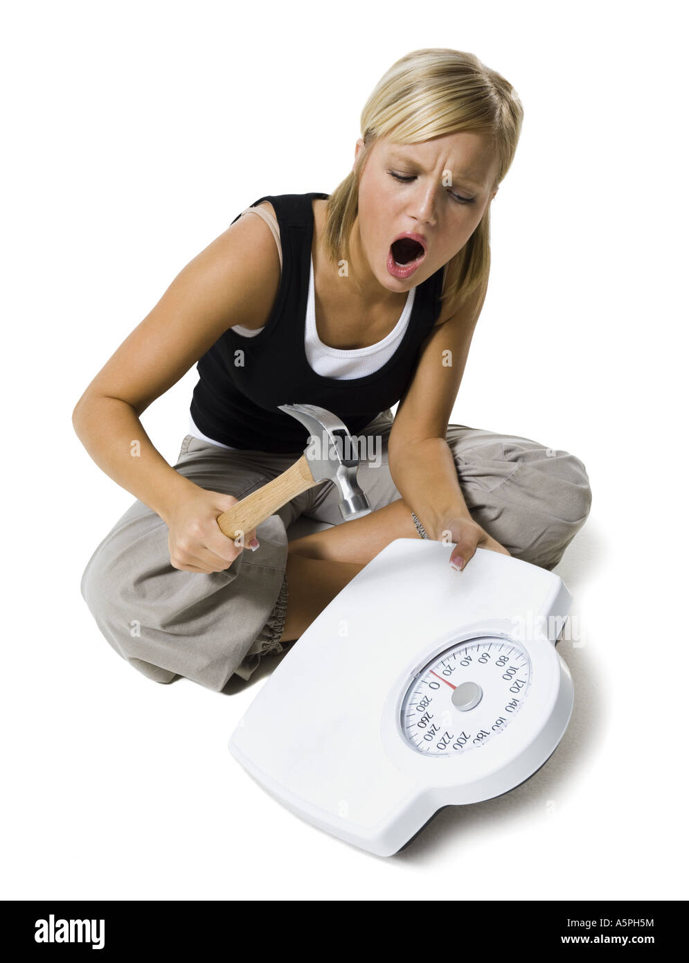 Frustrated dieting woman smashing bathroom scale with a hammer Stock ...