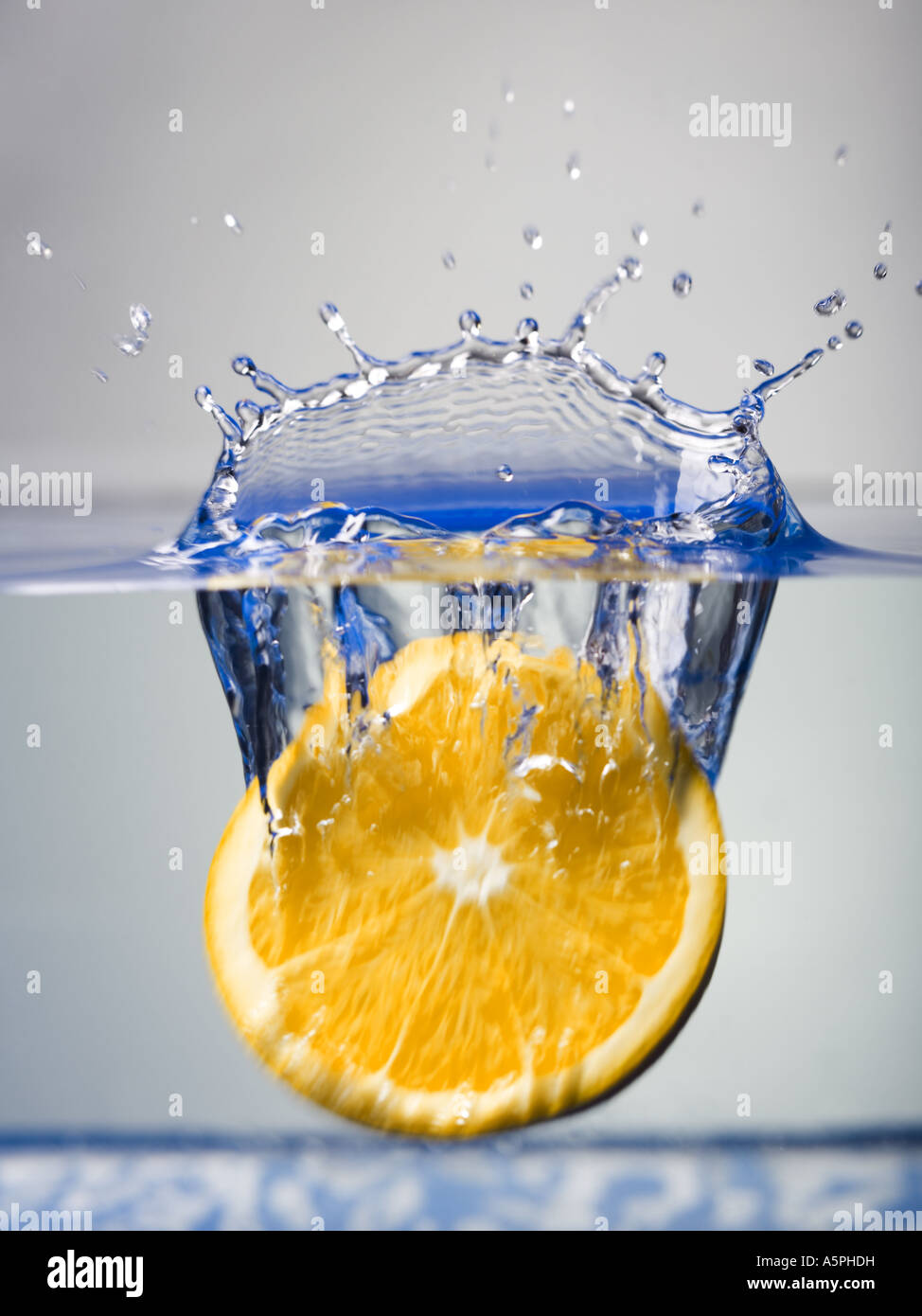Lemon slice dropping into water Stock Photo - Alamy