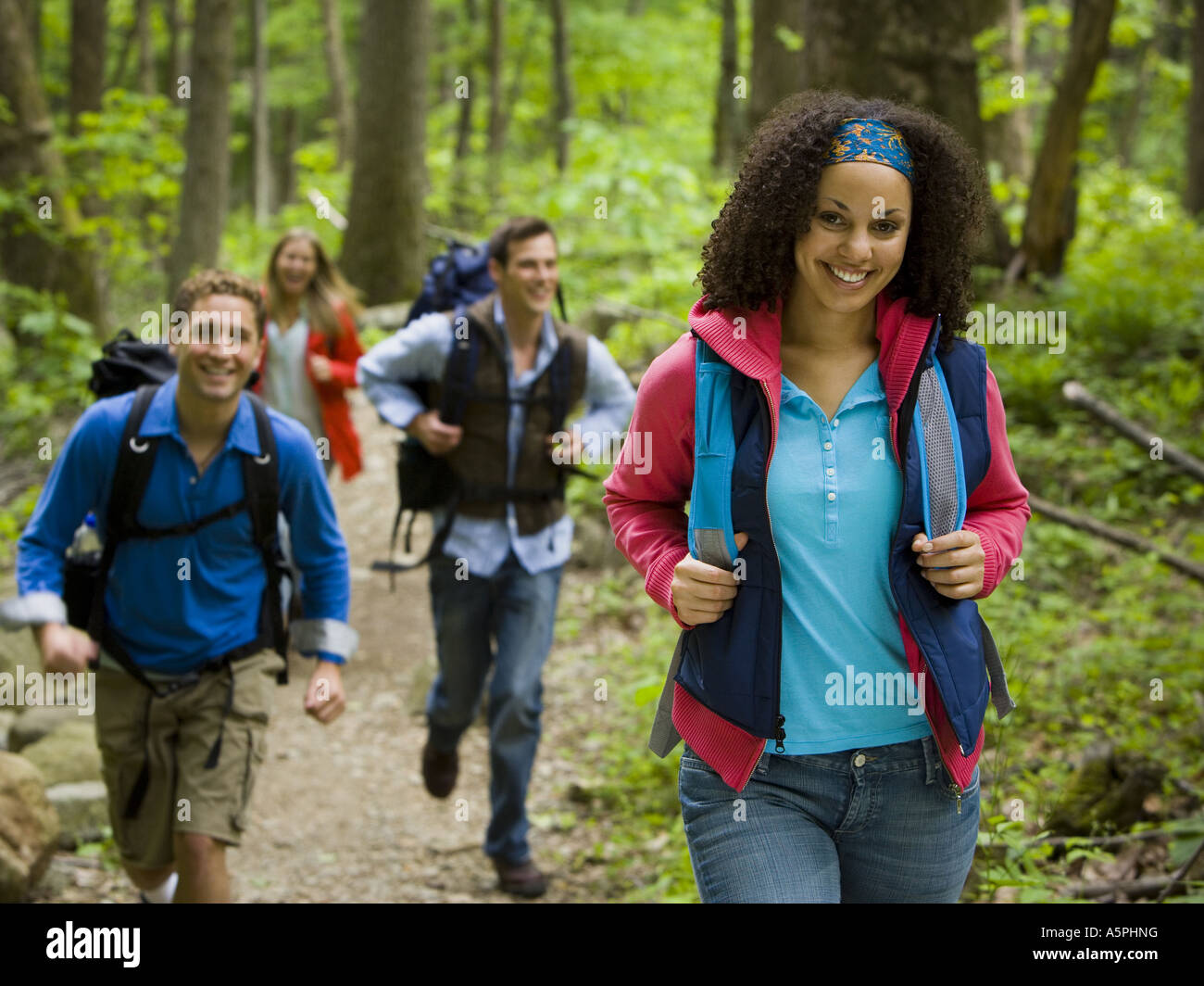 Four young adults hiking in the forest Stock Photo - Alamy