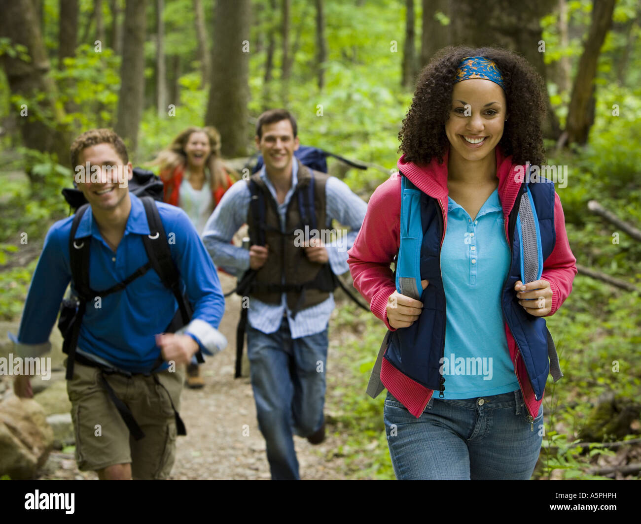 Four young adults hiking in the forest Stock Photo - Alamy