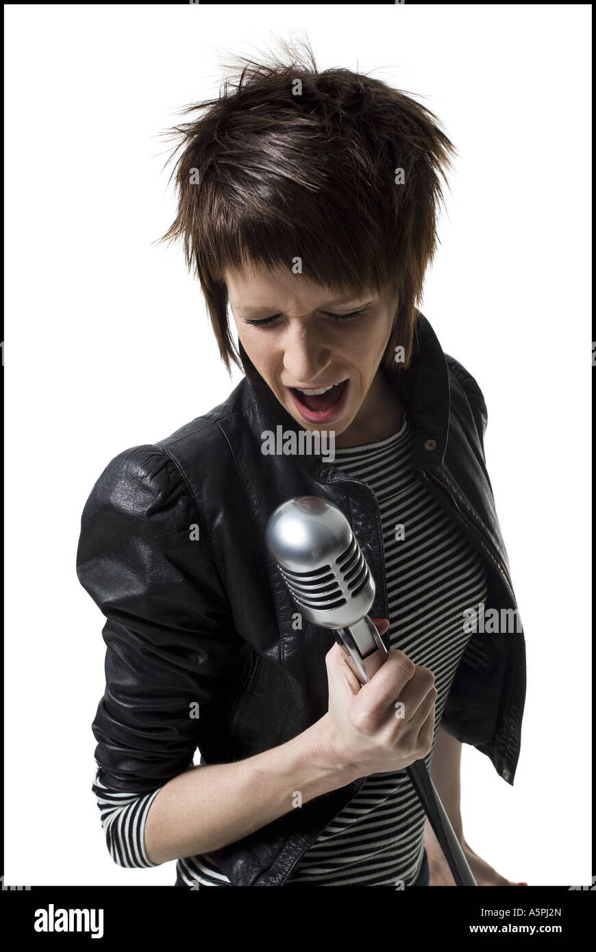 A young woman singing into a microphone Stock Photo - Alamy