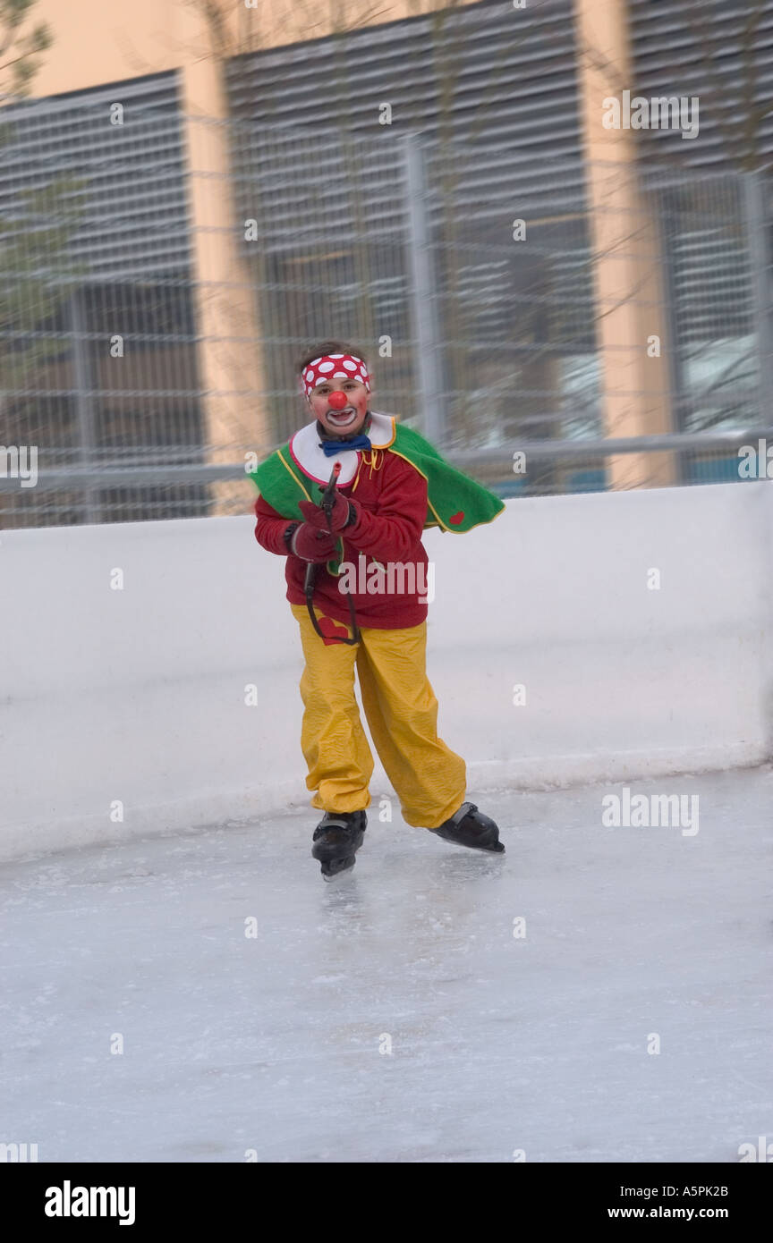 A nine year old boy diguised as a clown is skating during carneval ...
