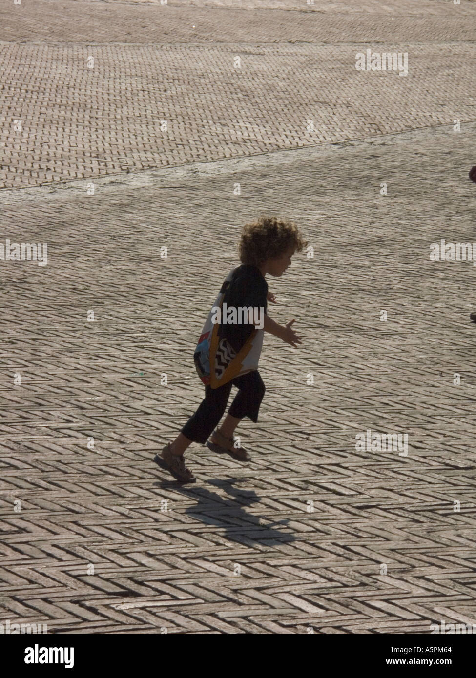 Boy running in the central square Stock Photo - Alamy