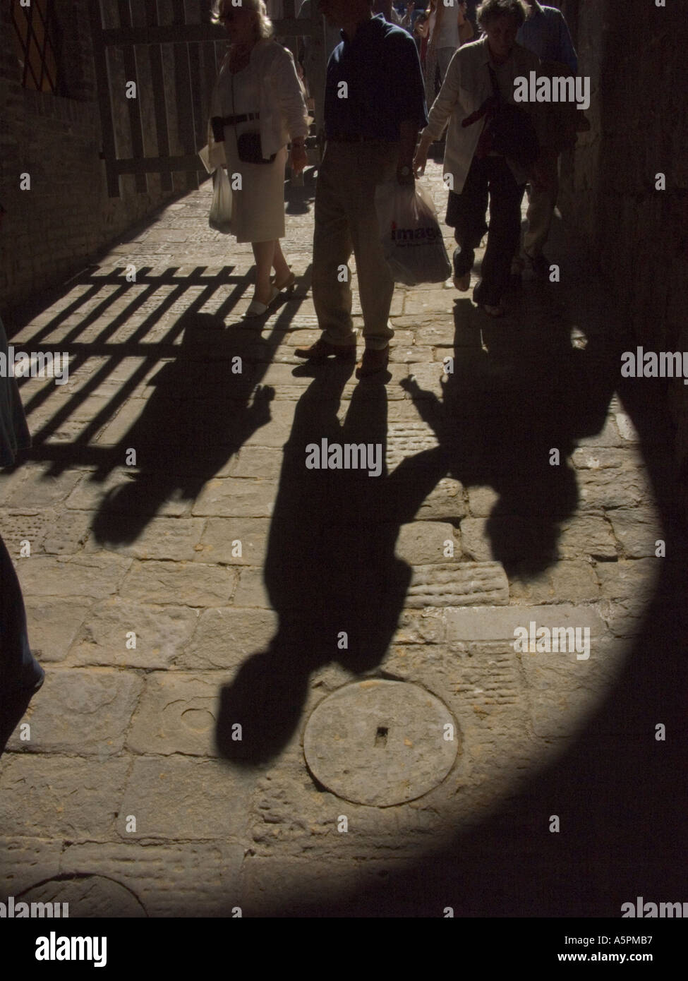 The shadows of pedestrians in an alley off the central square of Siena ...
