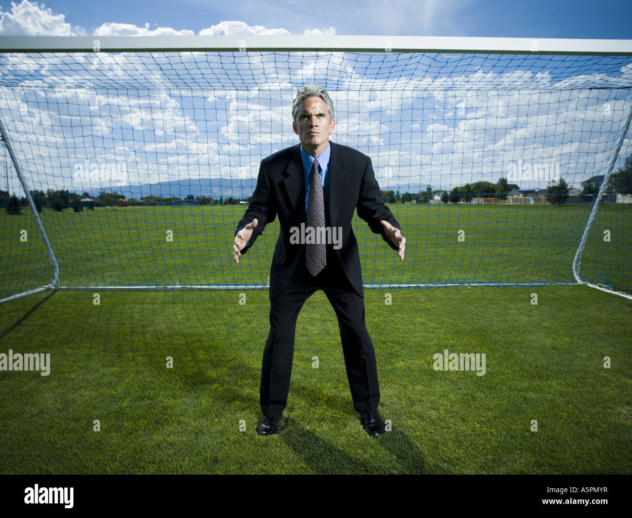 Businessman defending goal on soccer field Stock Photo - Alamy