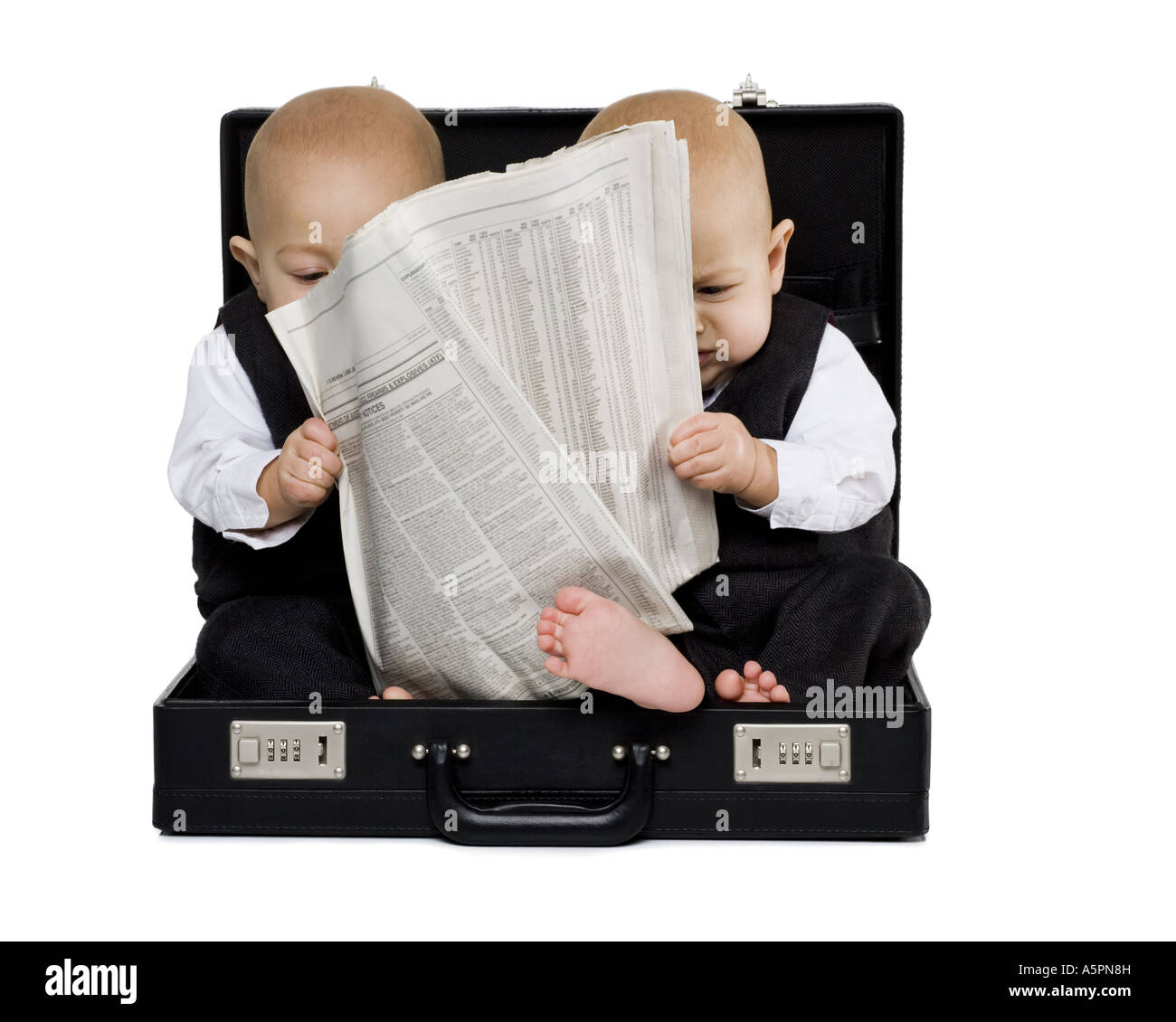 Twin boys sitting in a briefcase with newspaper Stock Photo - Alamy